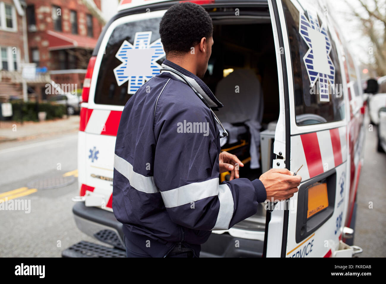 Mixed race paramedic opening ambulance Stock Photo - Alamy