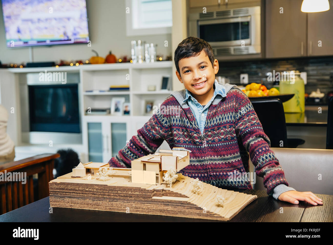 Mixed race boy smiling with model house Stock Photo - Alamy