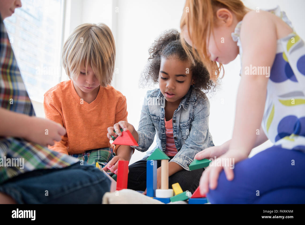 Children playing with blocks on floor Stock Photo - Alamy