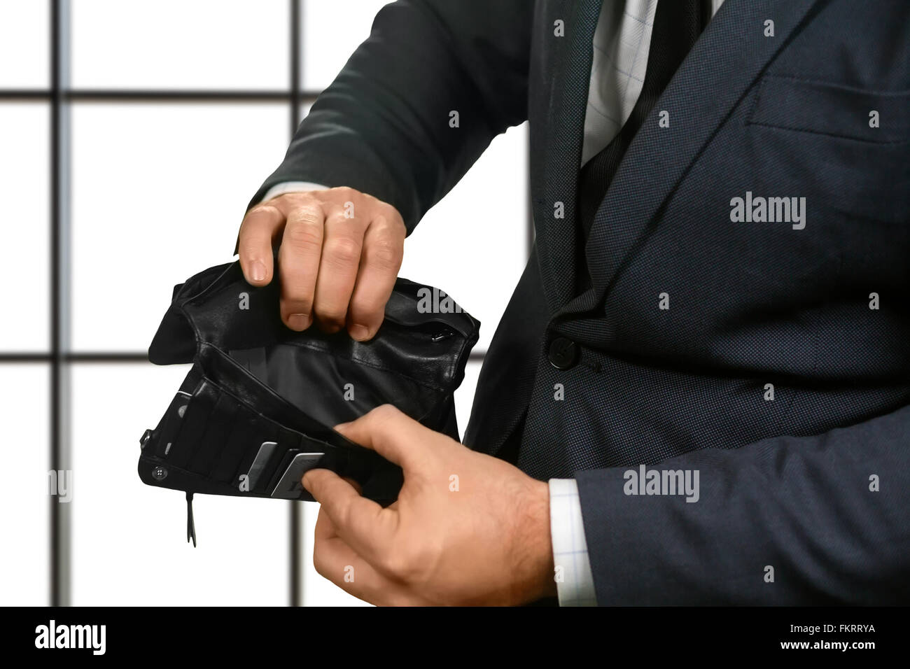 Office employee holding empty wallet Stock Photo - Alamy
