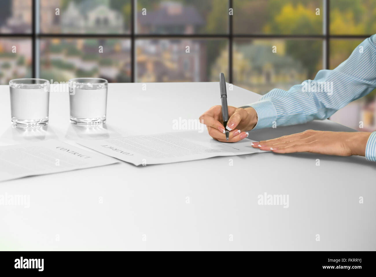 Woman signs contract at office Stock Photo - Alamy