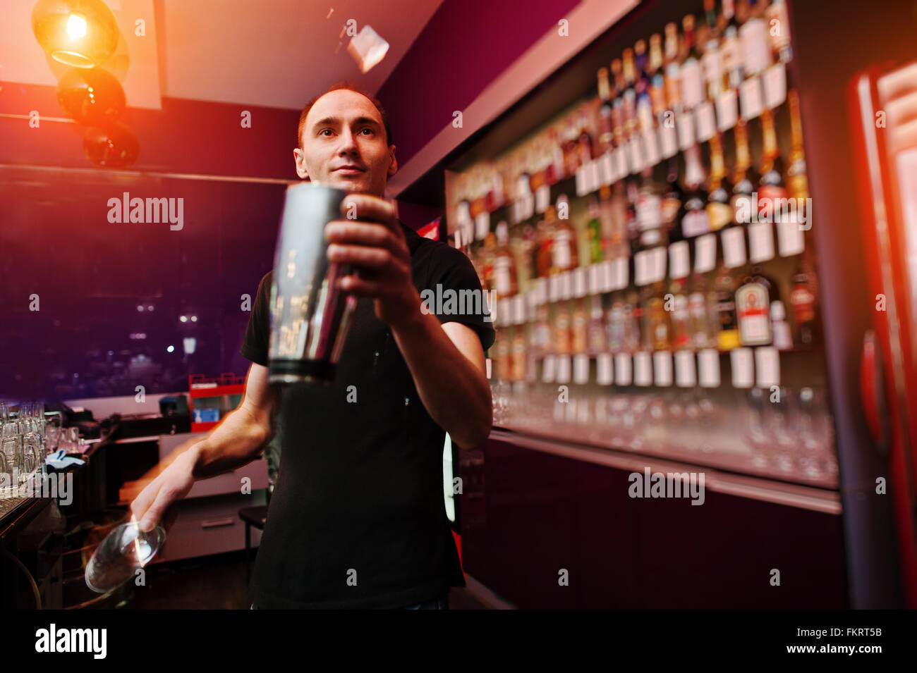 Young barman throws ice at the bar Stock Photo - Alamy
