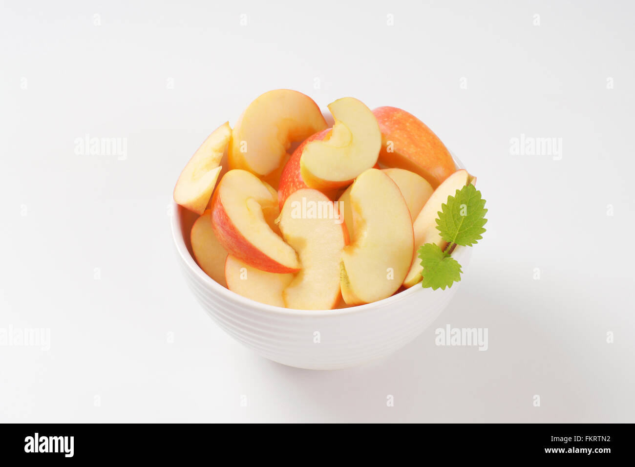 bowl of apple slices on white background Stock Photo - Alamy