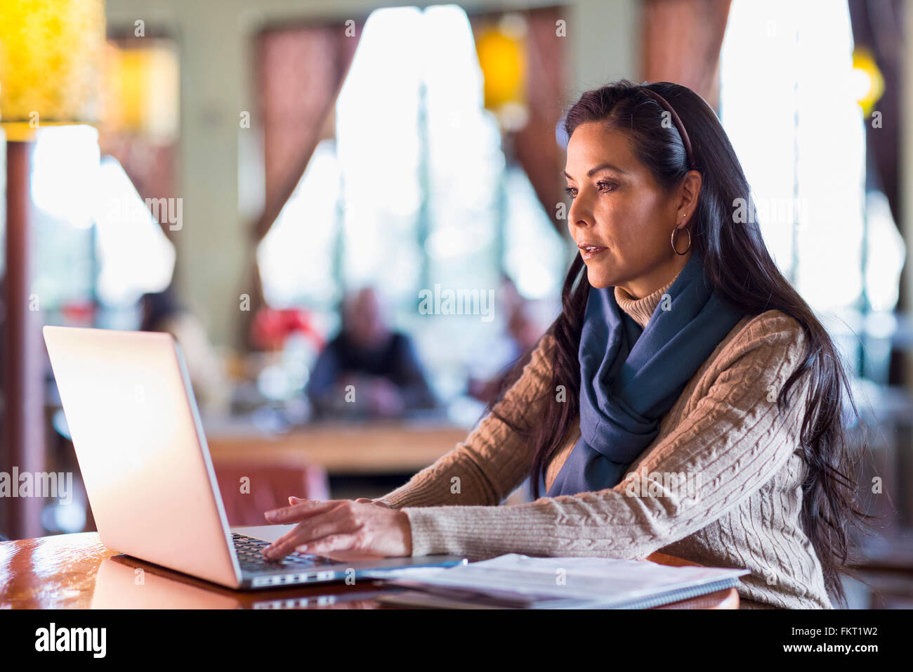 Hispanic woman using laptop in cafe Stock Photo - Alamy