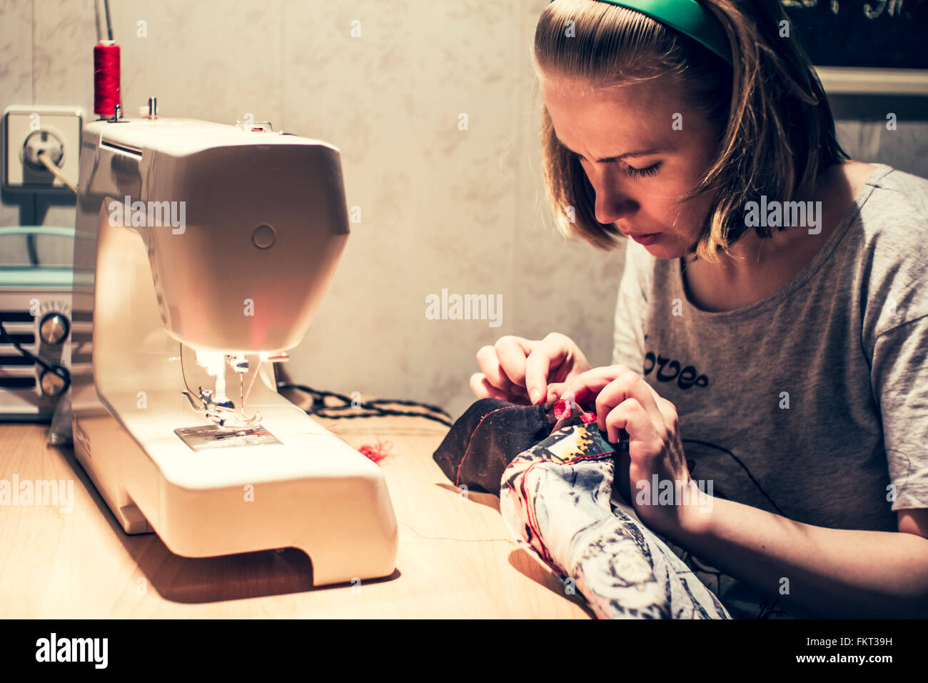 Caucasian woman using sewing machine Stock Photo - Alamy
