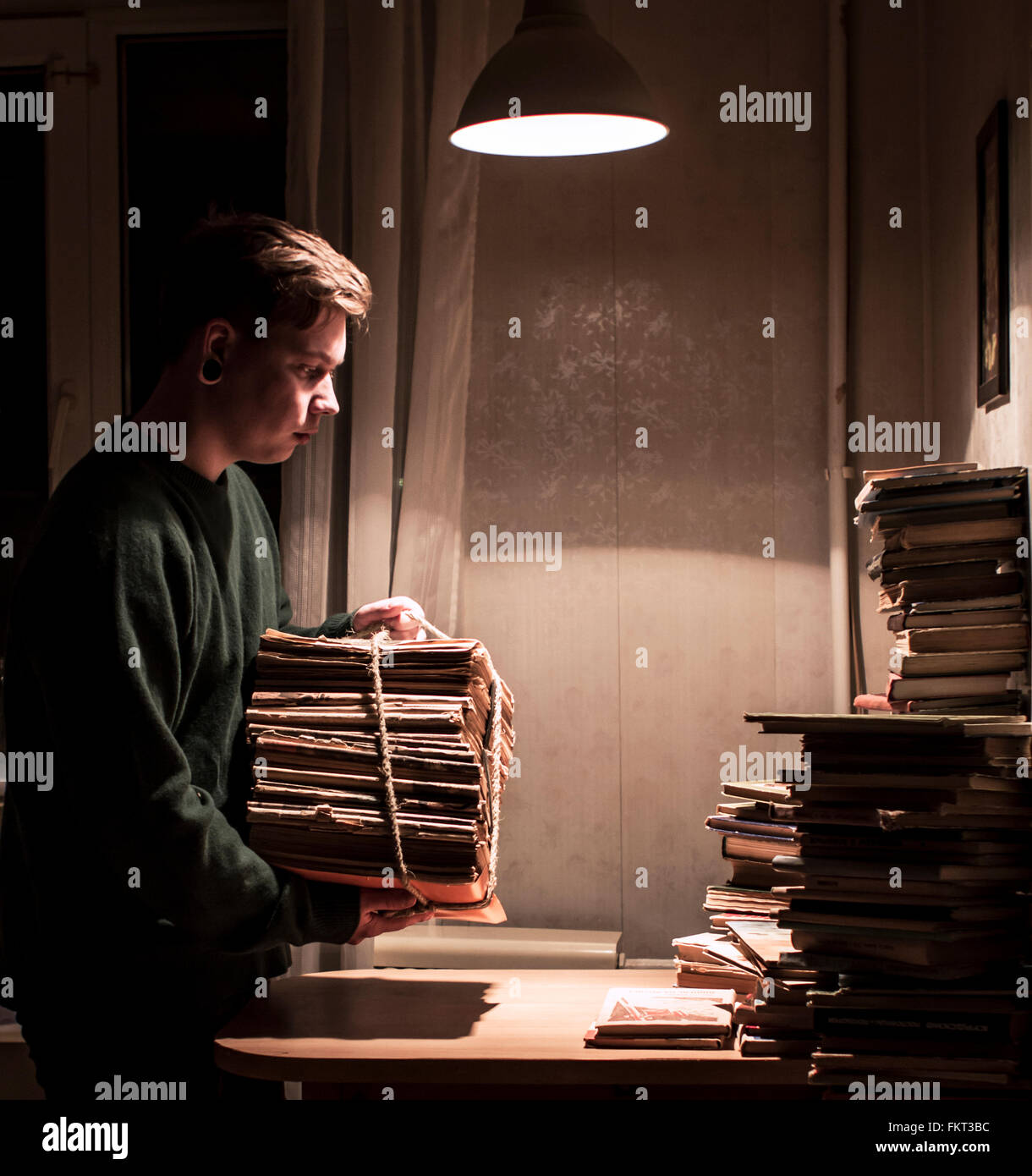 Caucasian man holding stack of books Stock Photo - Alamy
