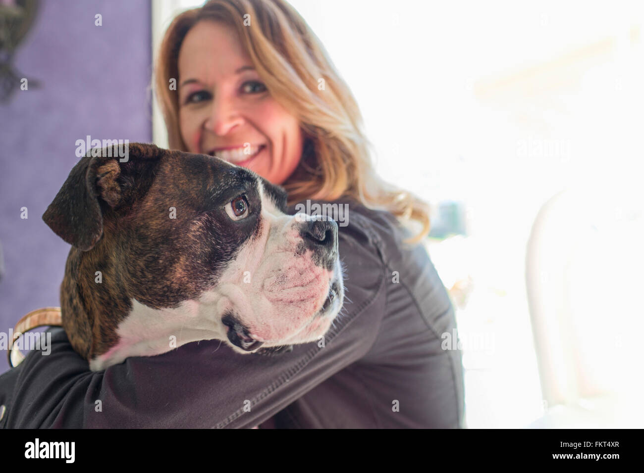 Caucasian woman hugging dog Stock Photo - Alamy