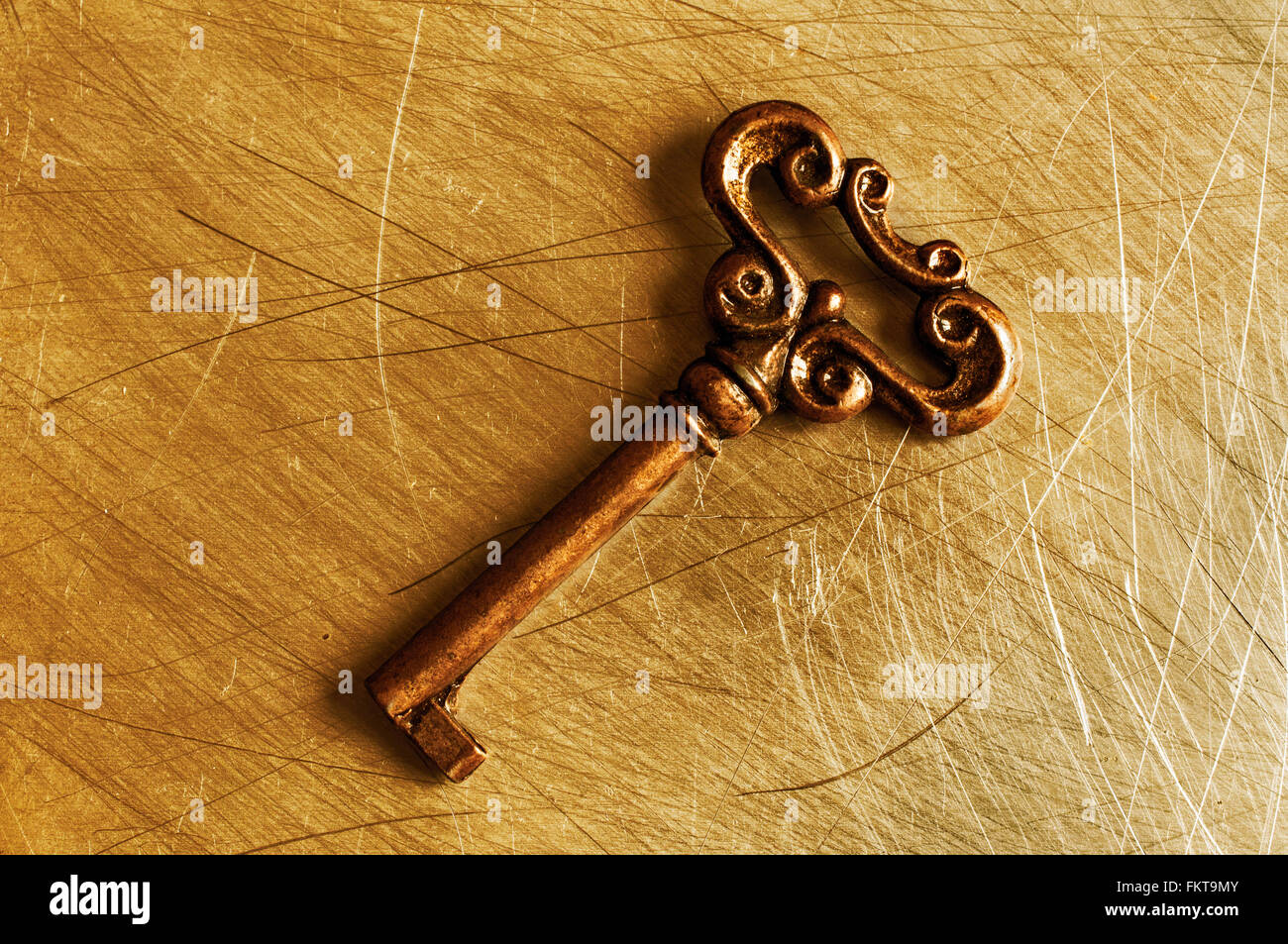 Bronze old key on a bronze scratch background Stock Photo - Alamy