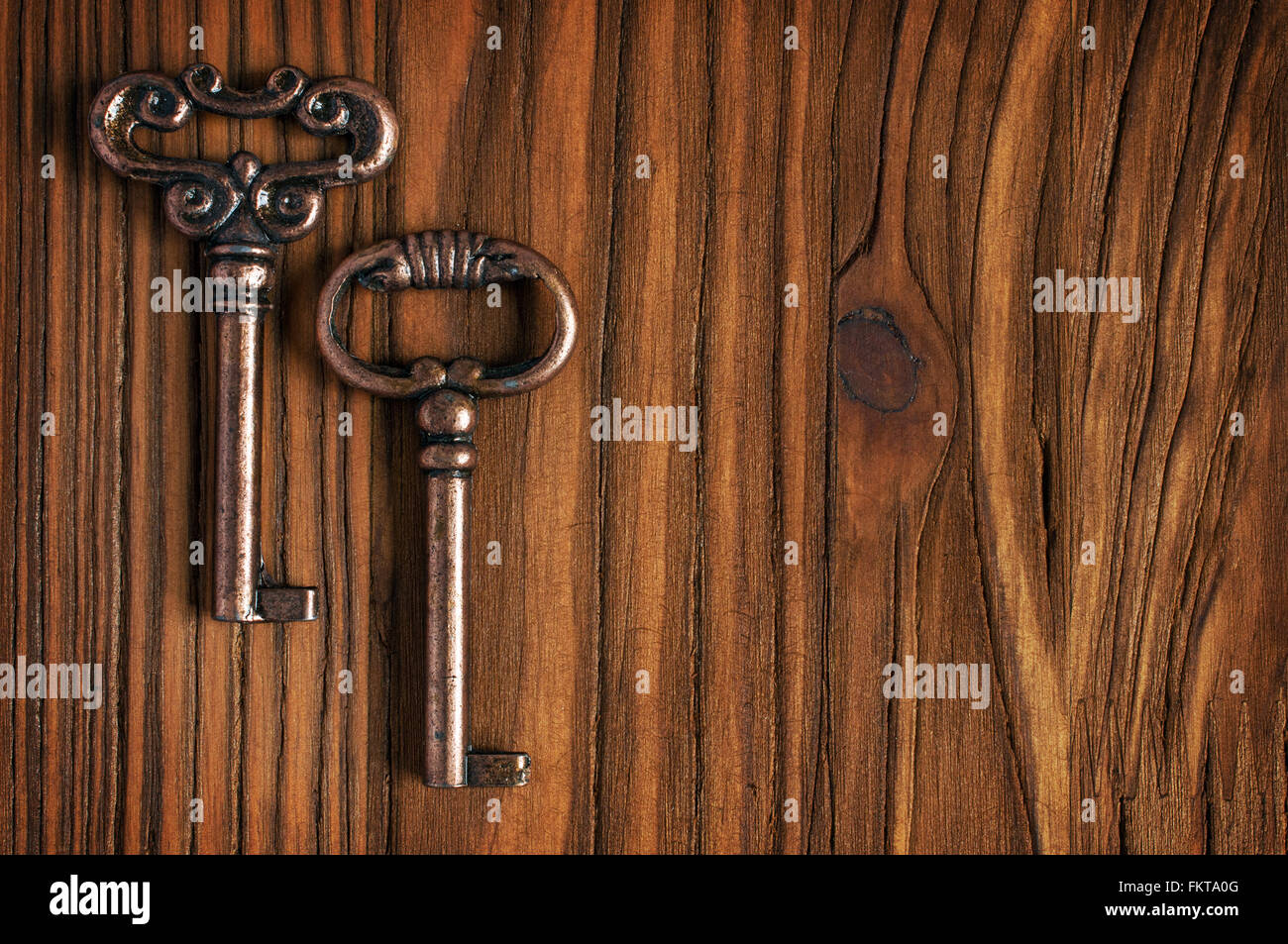 Bronze vintage keys on a wooden background Stock Photo - Alamy