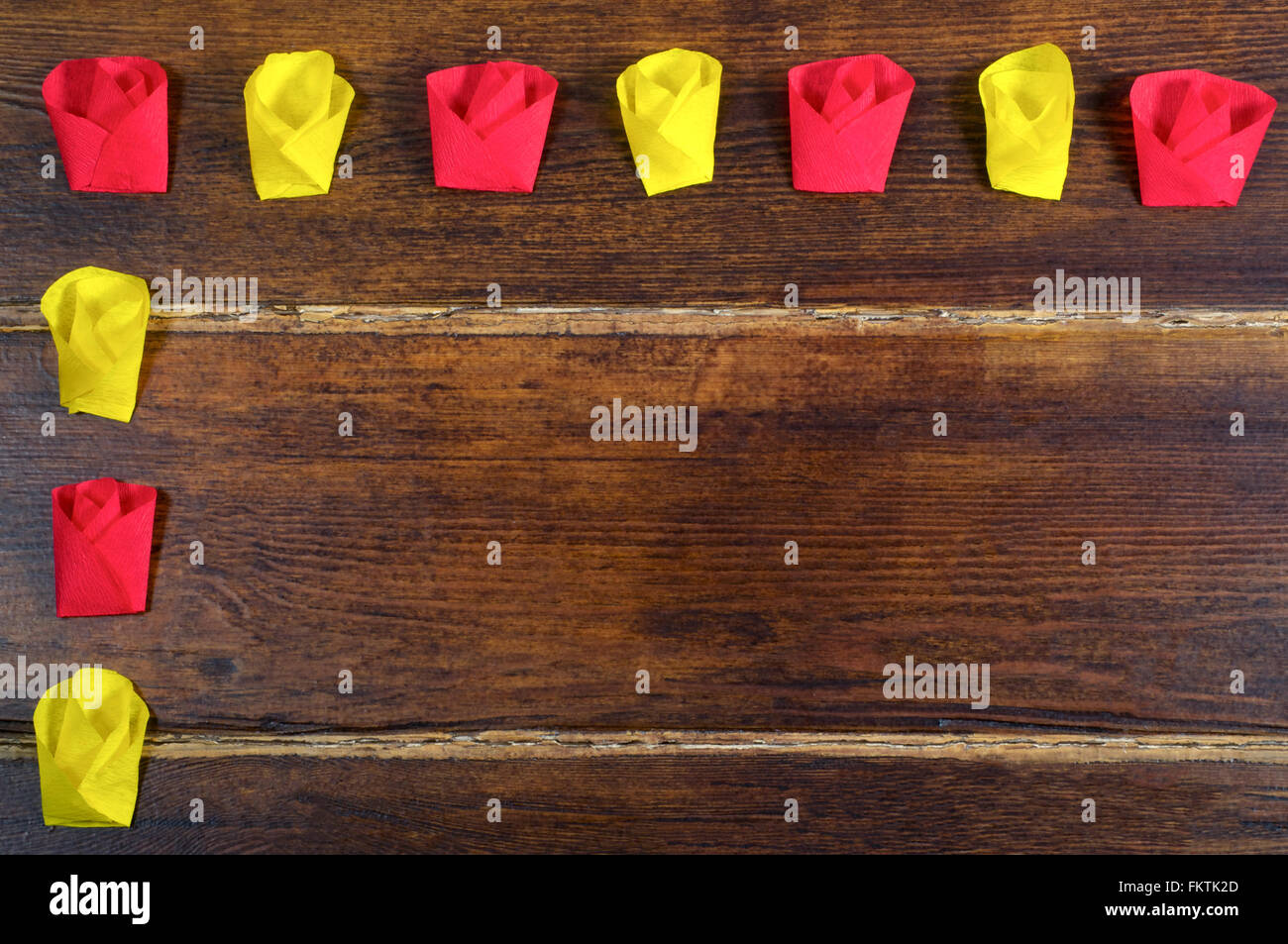 Red and yellow paper flowers over brown wooden background Stock Photo ...