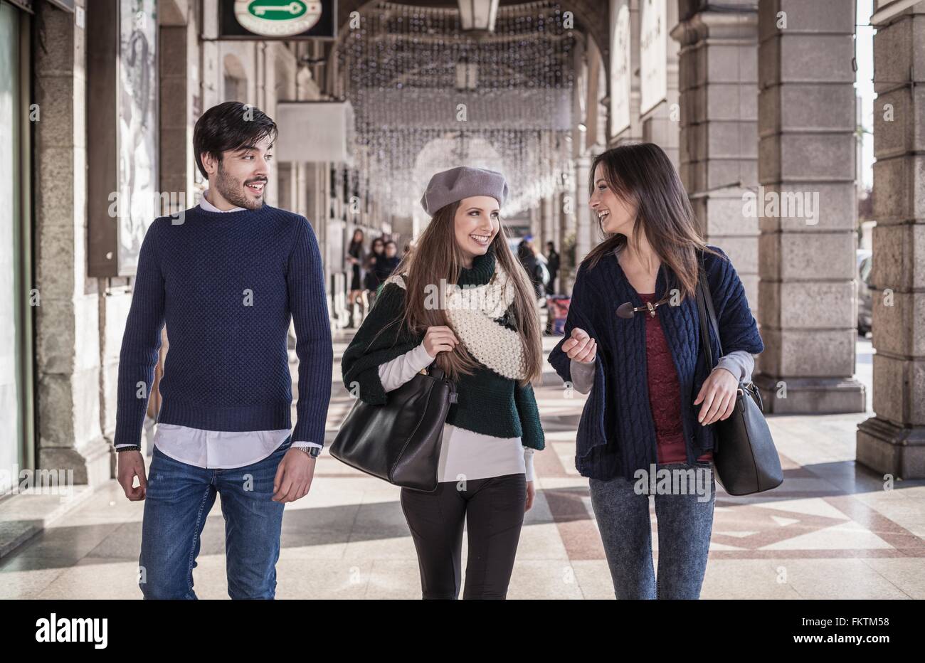 Front view friends walking side by side in shopping mall smiling Stock ...