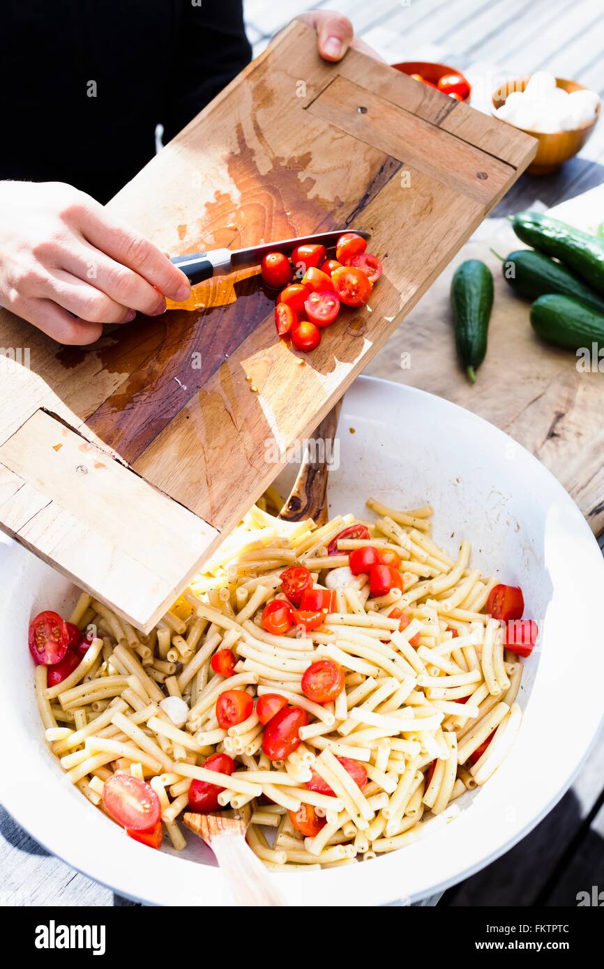 Woman scraping tomatoes into bowl with knife Stock Photo - Alamy