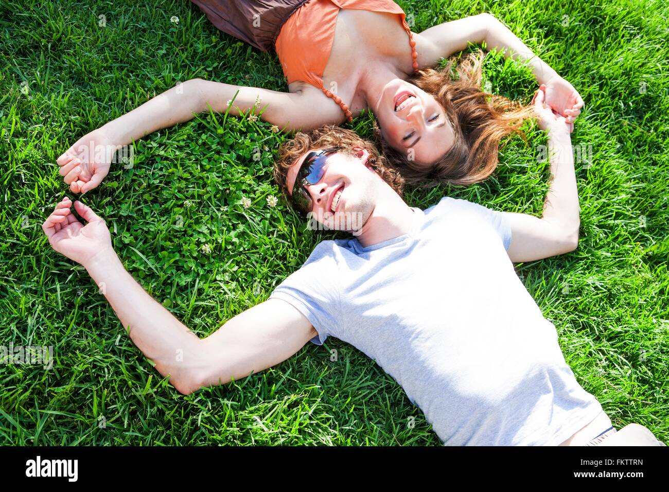 Overhead view of romantic young couple lying on garden lawn Stock Photo ...