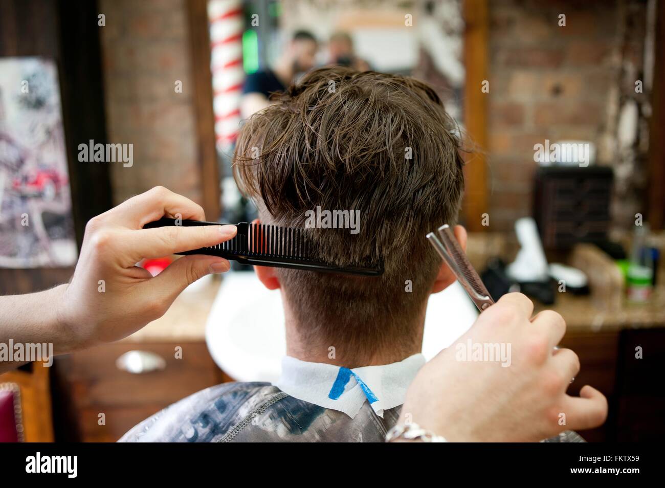 Rear view of young man in barbershop having haircut Stock Photo - Alamy