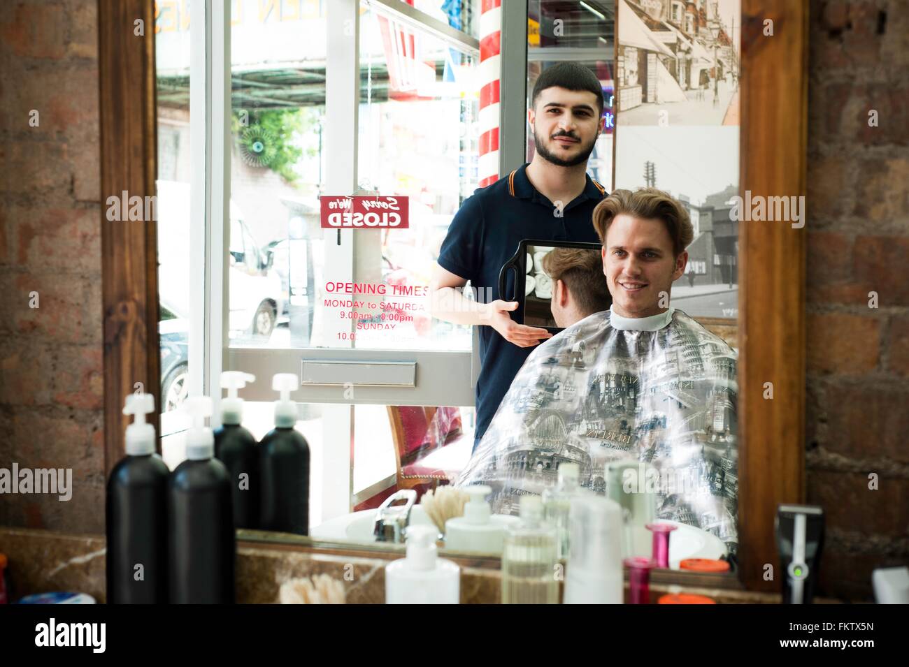 Mirror image of barber using mirror to show smiling customer haircut ... Mirror image of barber using mirror to show smiling customer haircut ...