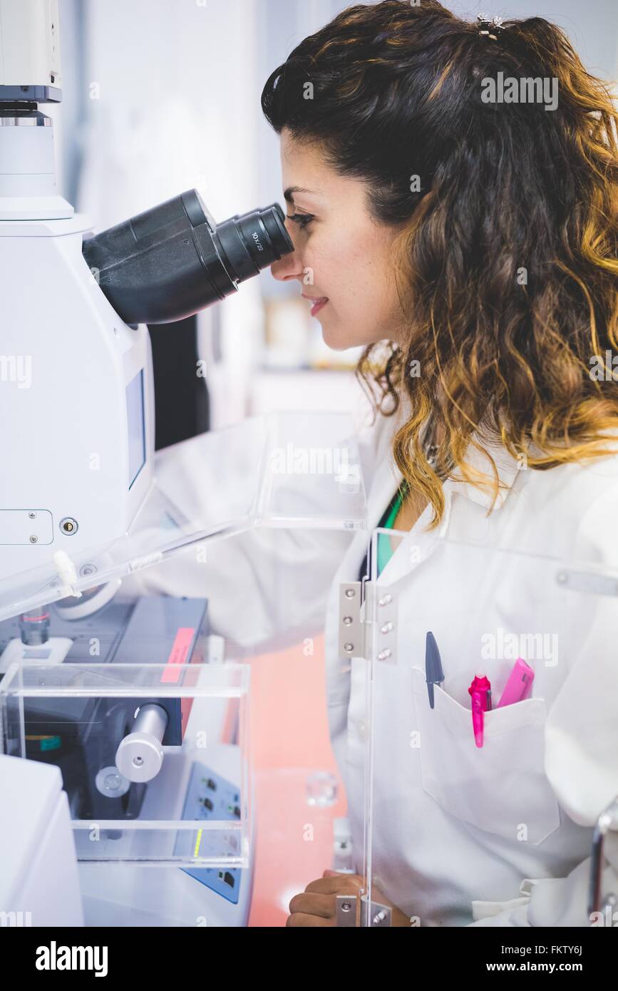 Female scientist using FTIR spectrophotometer, looking at thin film ...