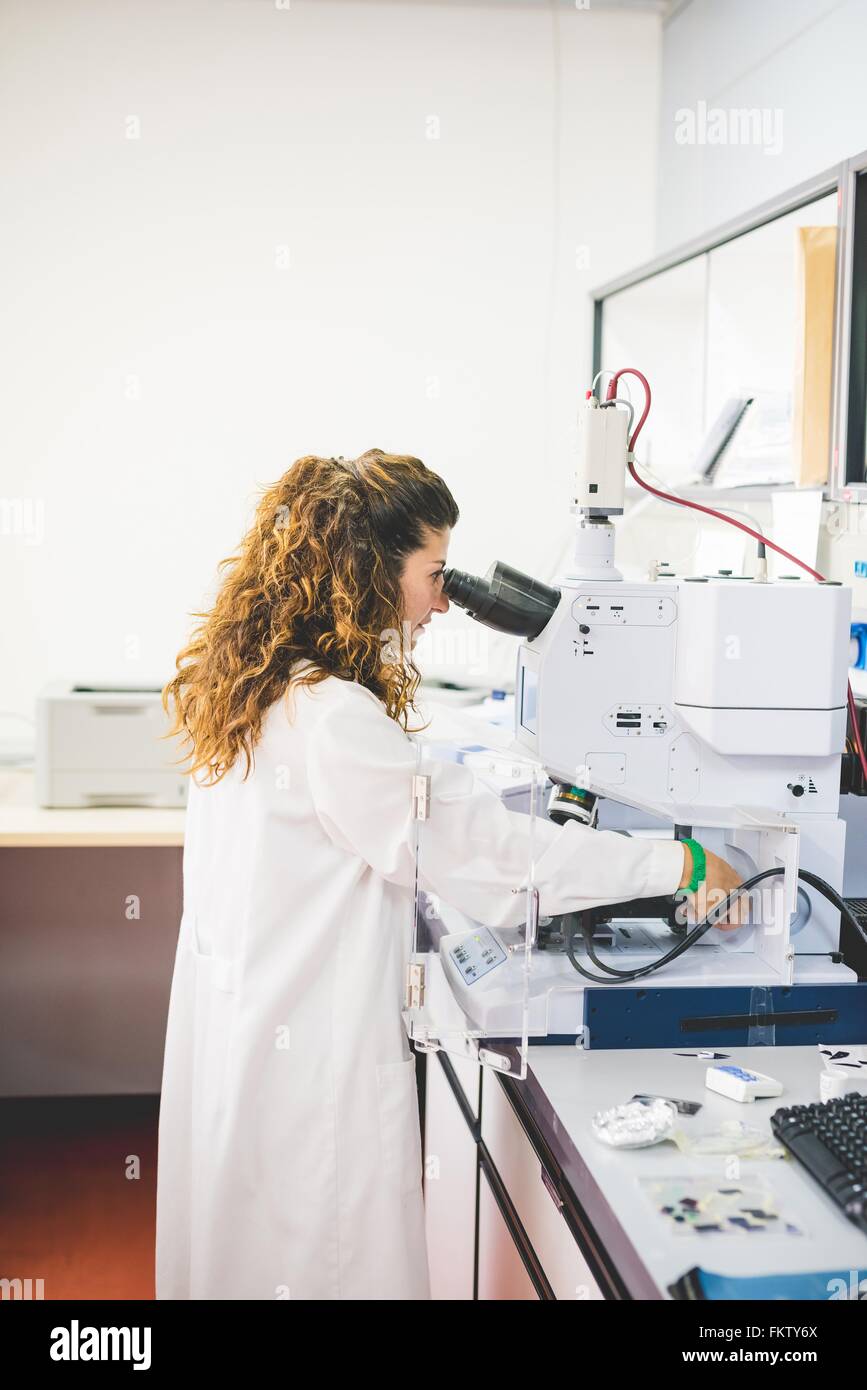 Female scientist using FTIR spectrophotometer, looking at thin film ...