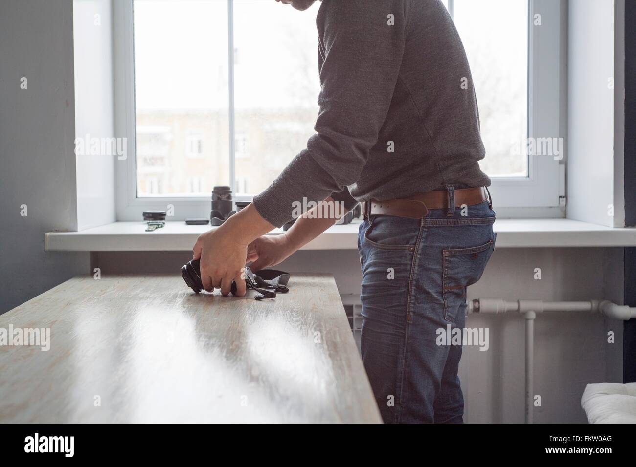 Male photographer checking camera on studio desk Stock Photo - Alamy