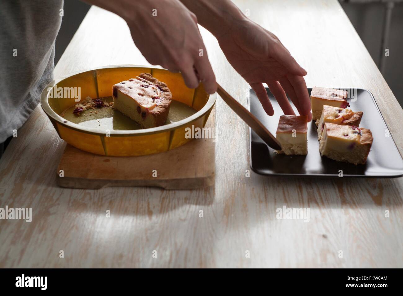 Female hands placing cake onto dish at kitchen counter Stock Photo - Alamy