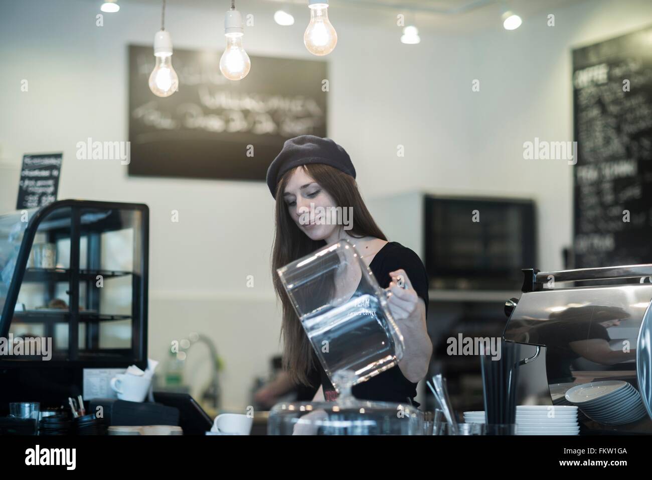 Young female waitress selecting cake at cafe counter Stock Photo - Alamy