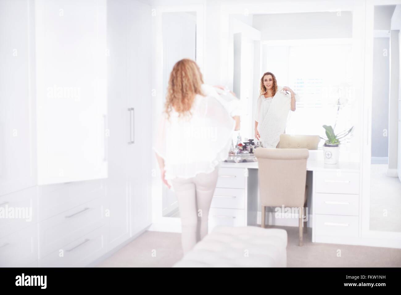 Young woman getting ready in bedroom mirror Stock Photo - Alamy