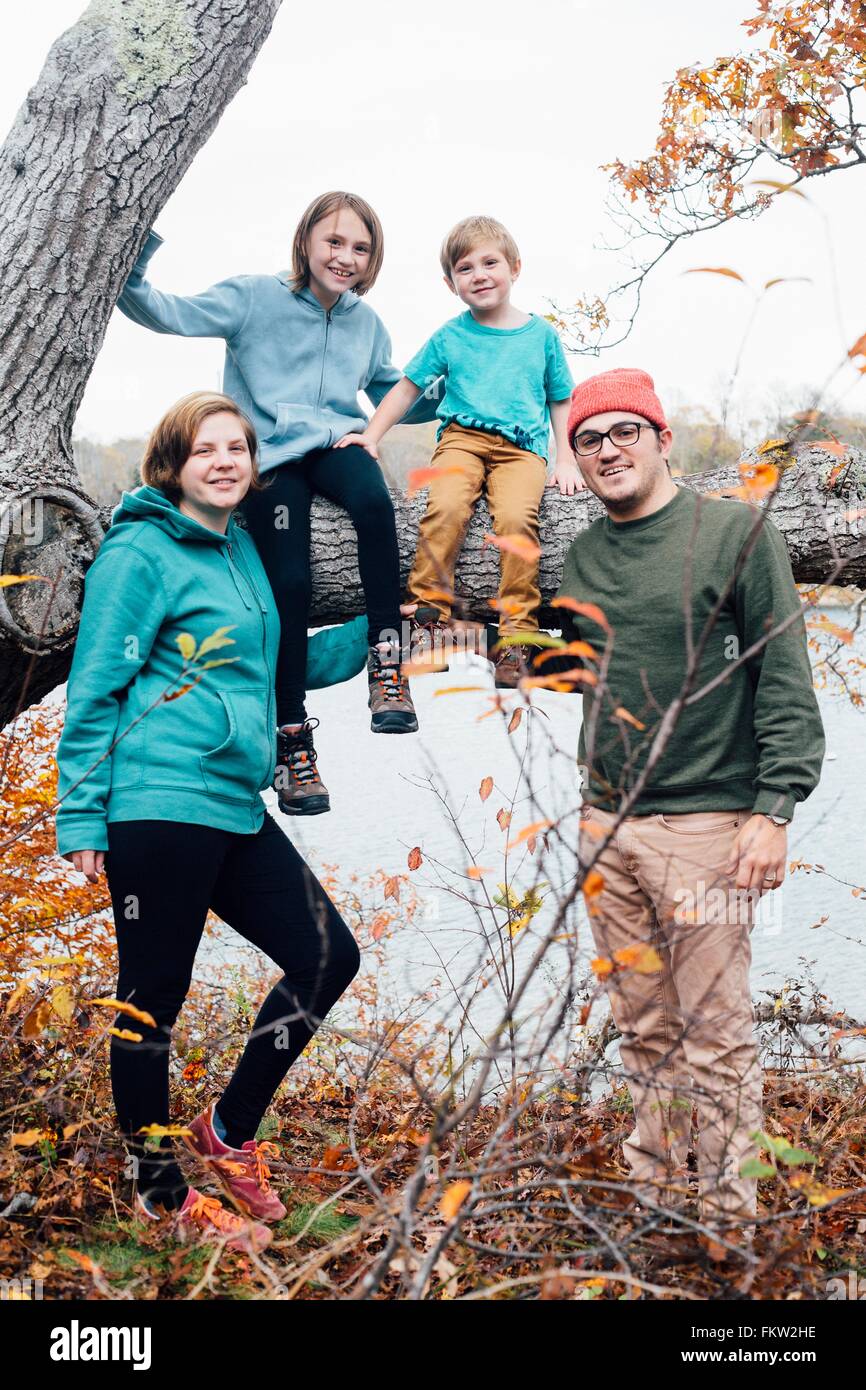 Portrait of family, children sitting on tree Stock Photo - Alamy