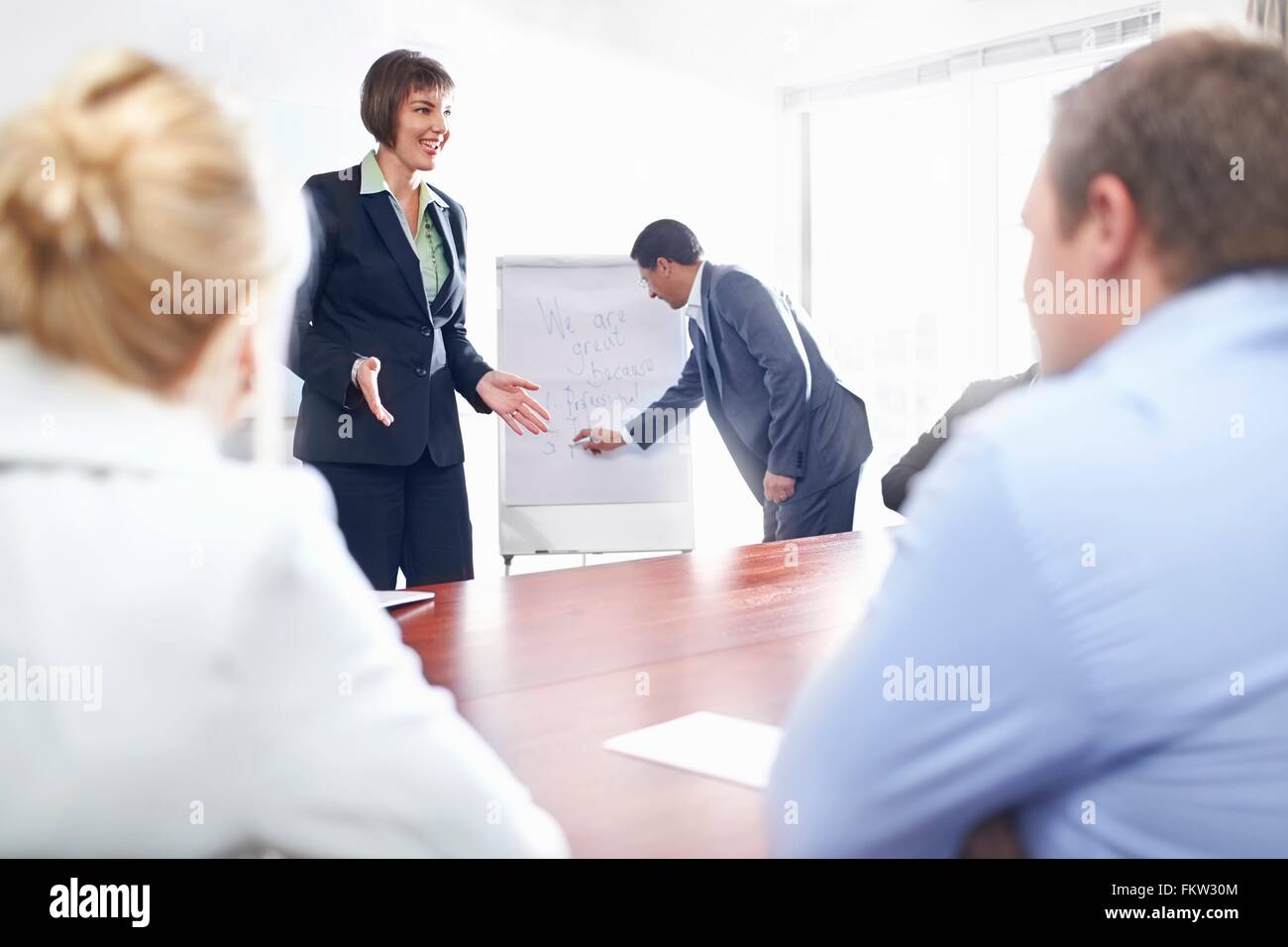 Over shoulder view of colleagues in conference room watching ...