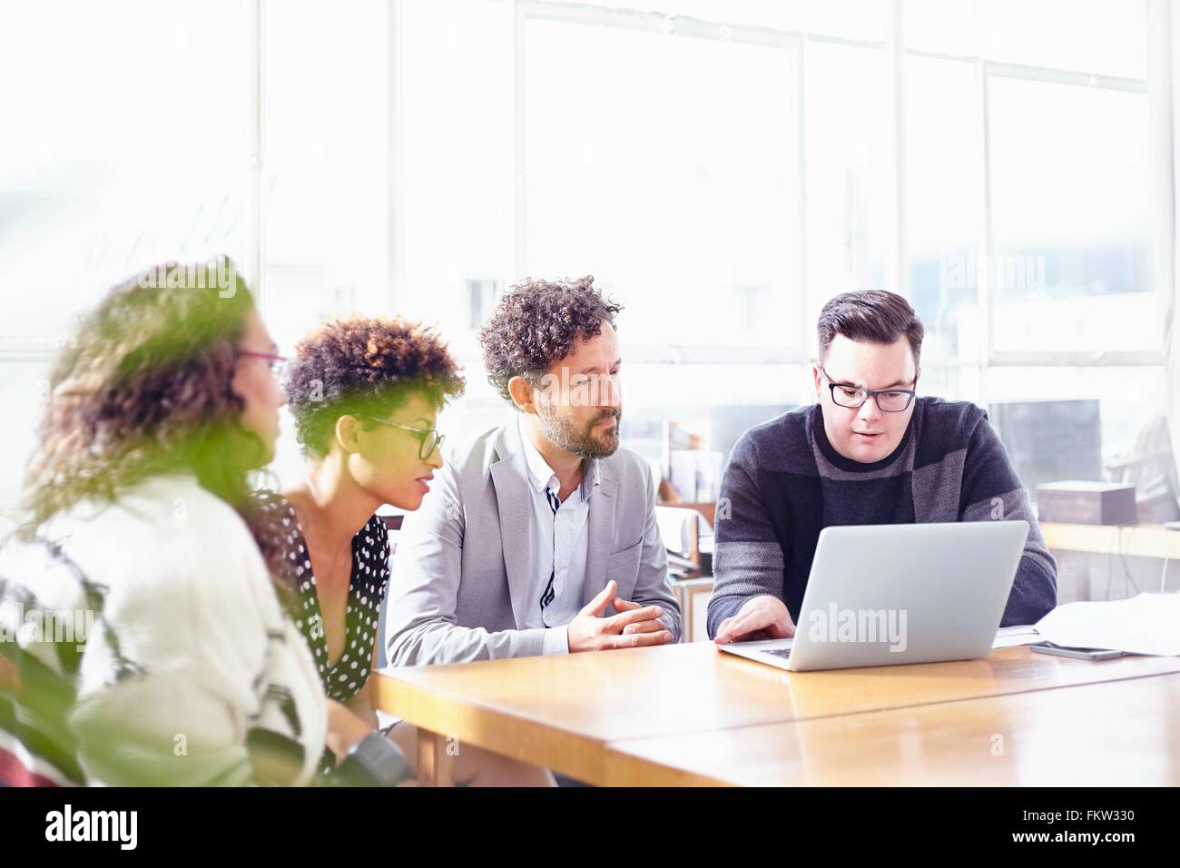 Young man in fice showing colleagues laptop Stock Photo - Alamy