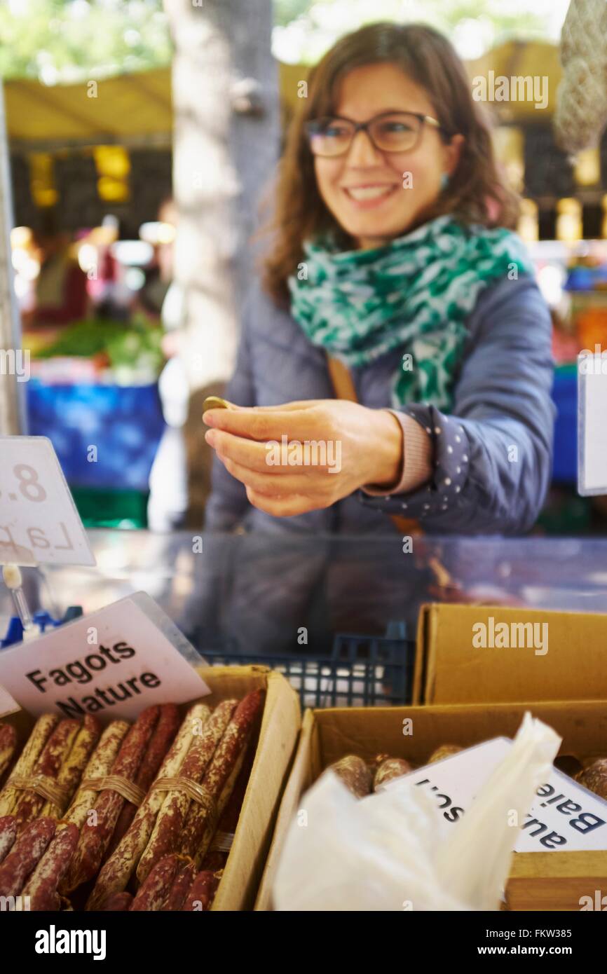 Young woman buying goods at market stall Stock Photo - Alamy