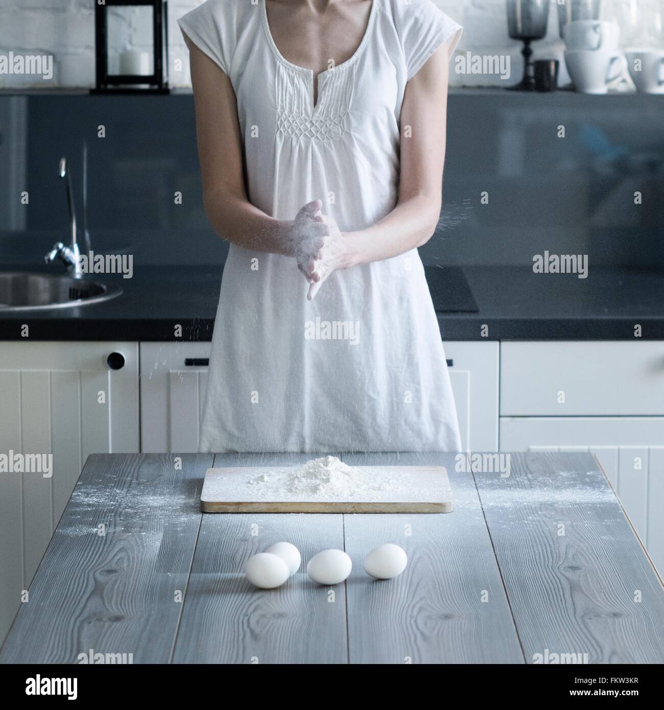 Cropped shot of woman baking with flour at kitchen table Stock Photo ...