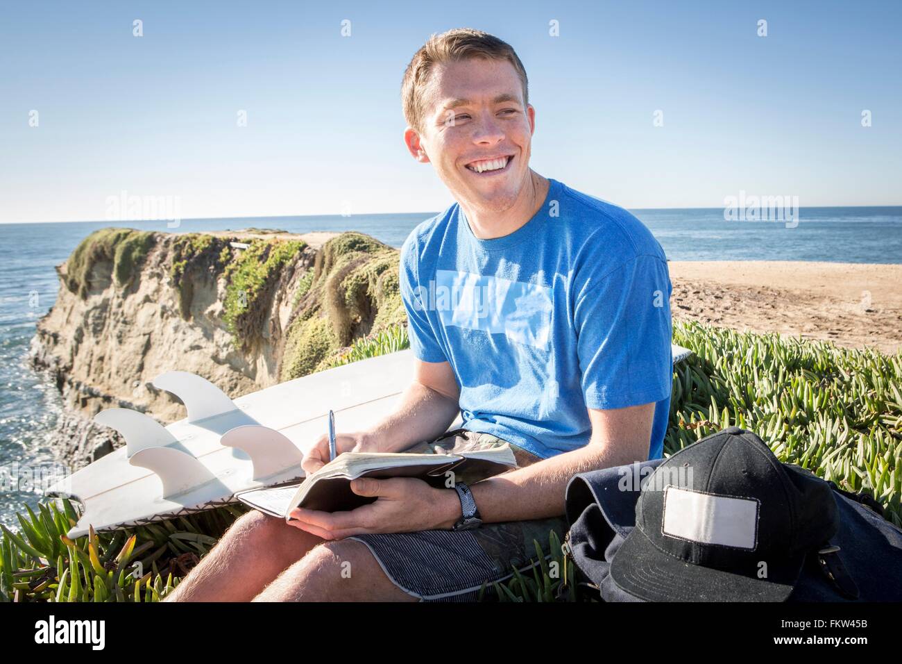 Young man sitting by cliff edge hi-res stock photography and images - Alamy