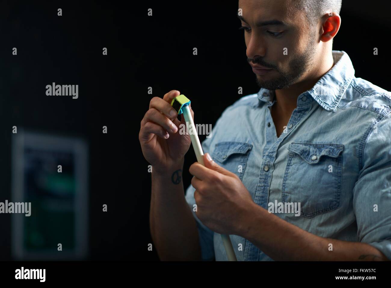 Man chalk rubbing pool cue Stock Photo - Alamy