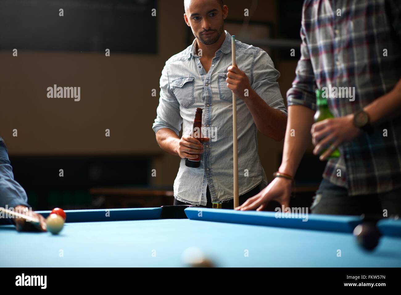 Men with beer standing at pool table Stock Photo - Alamy