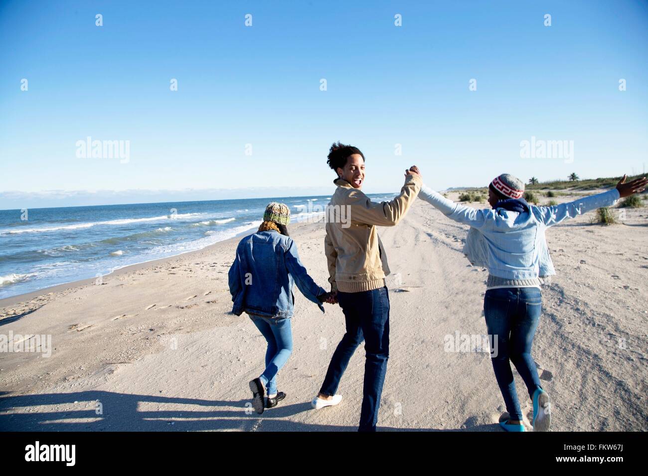 People Walking On The Beach Holding Hands