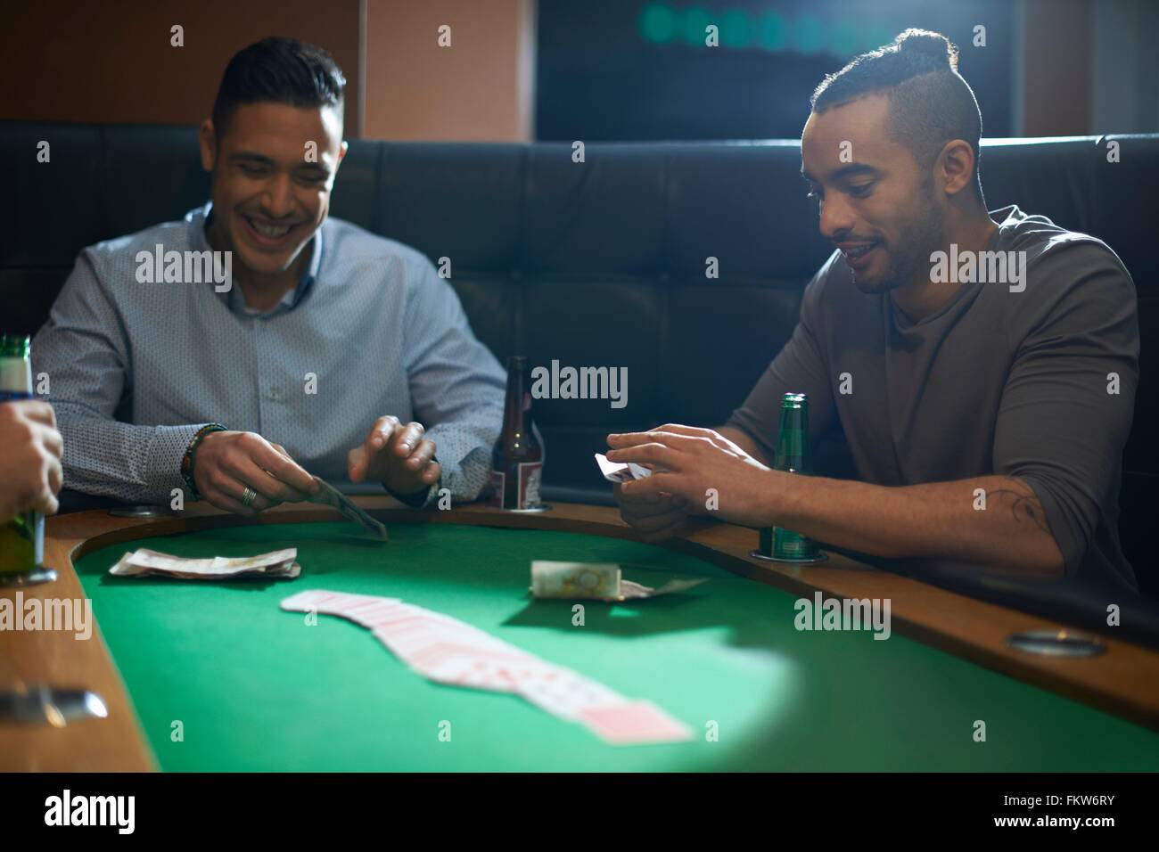 Men placing cash for card game at pub card table Stock Photo - Alamy