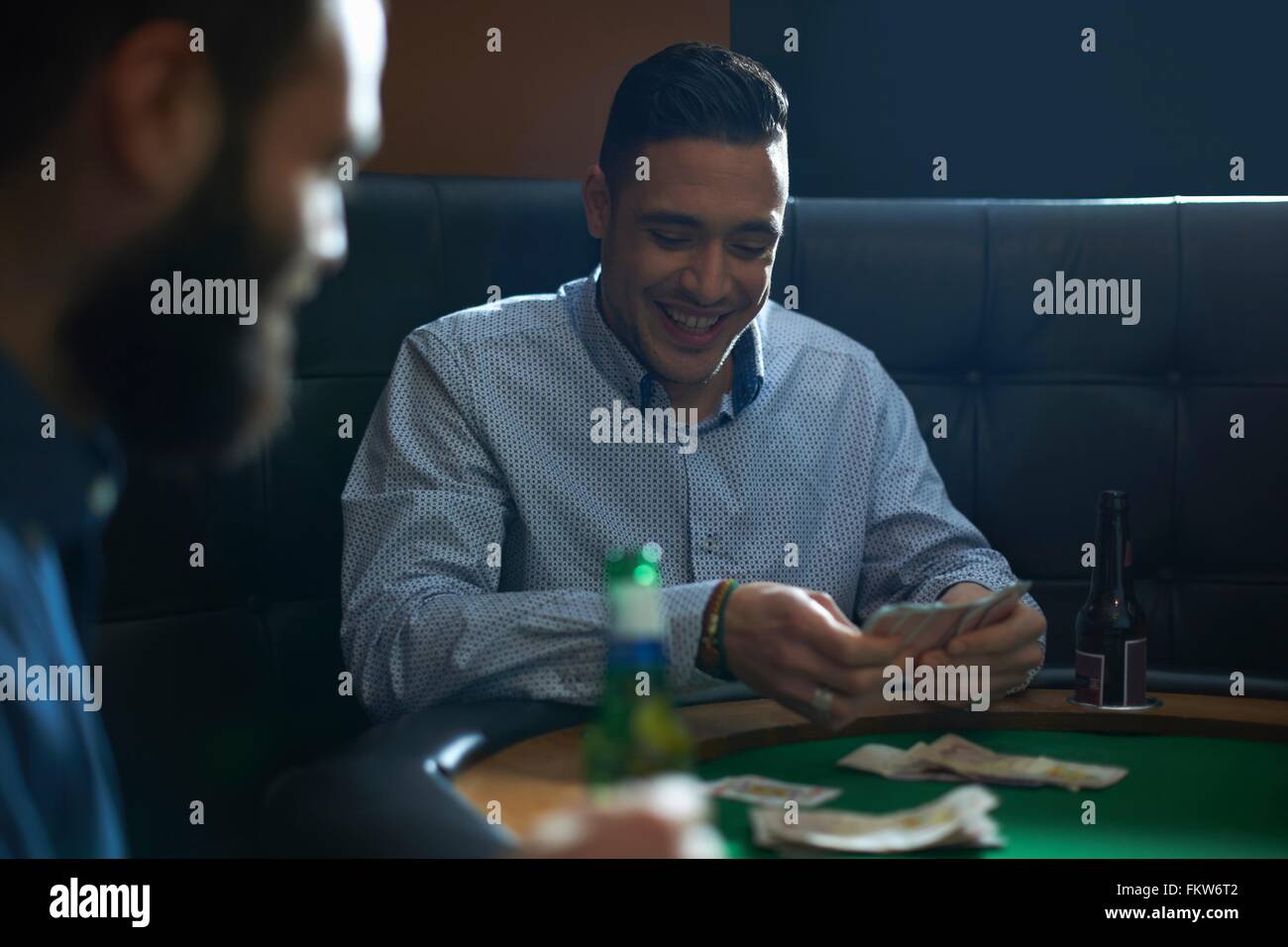 Male friends playing card game for cash at pub card table Stock Photo ...