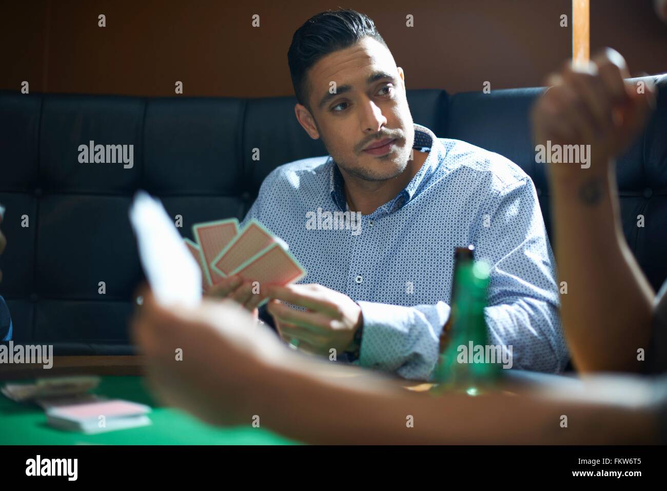 Male friends playing card game at pub card table Stock Photo - Alamy