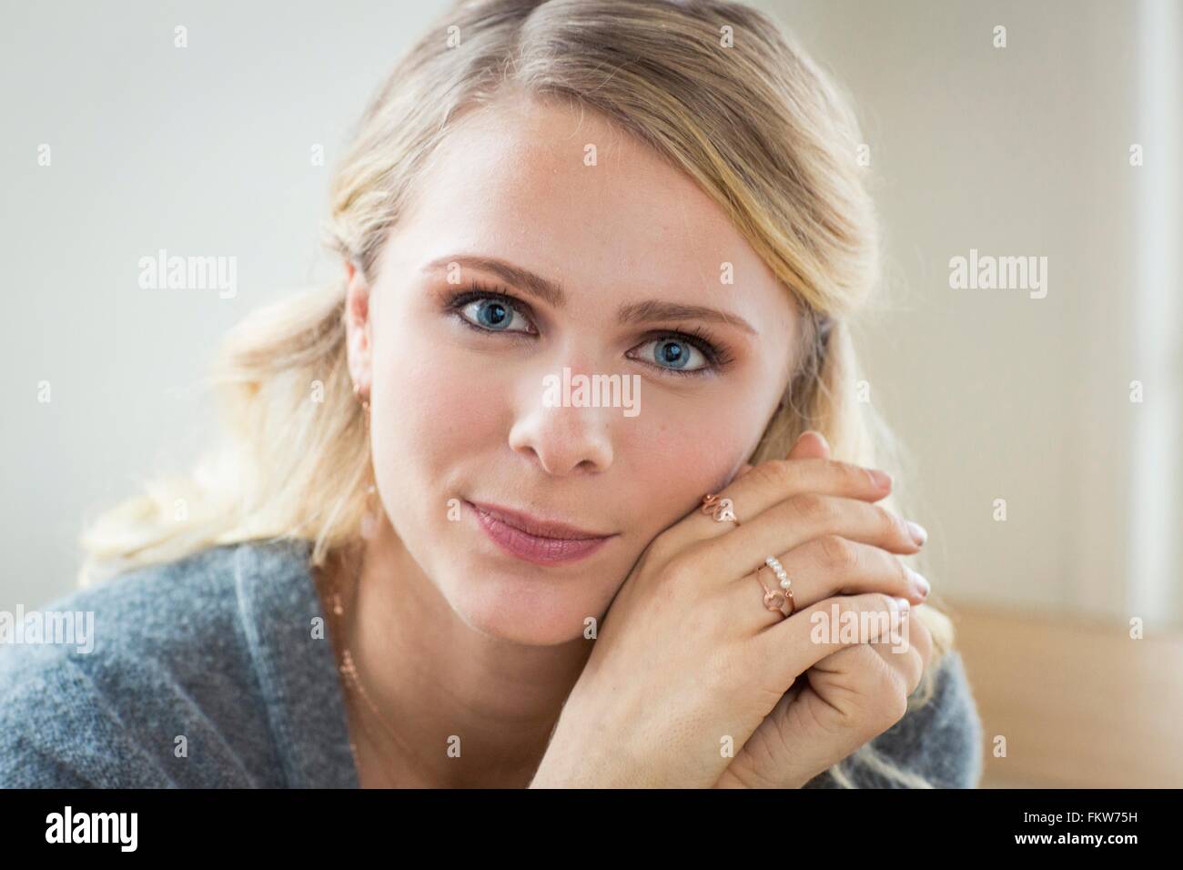 Portrait of young woman hand on cheek looking at camera smiling Stock ...
