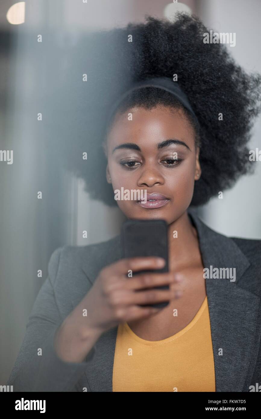 Young businesswomen reading smartphone text at office Stock Photo - Alamy