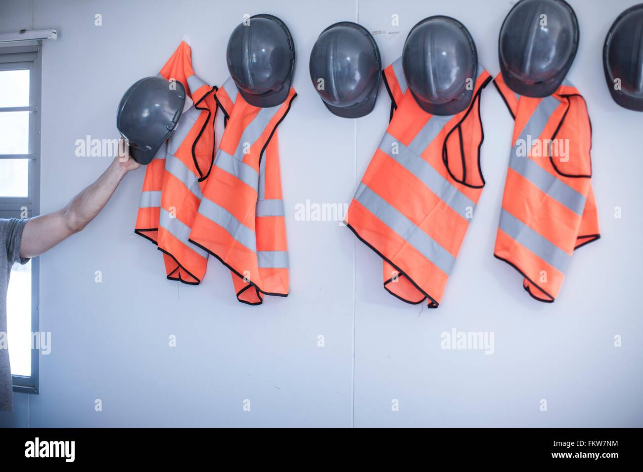 Builders hand removing hard hat from portable cabin wall Stock Photo ...