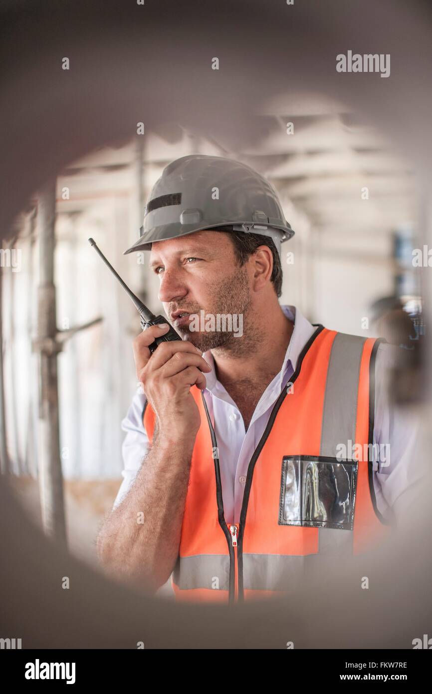 Site manager using walkie talkie on construction site Stock Photo - Alamy