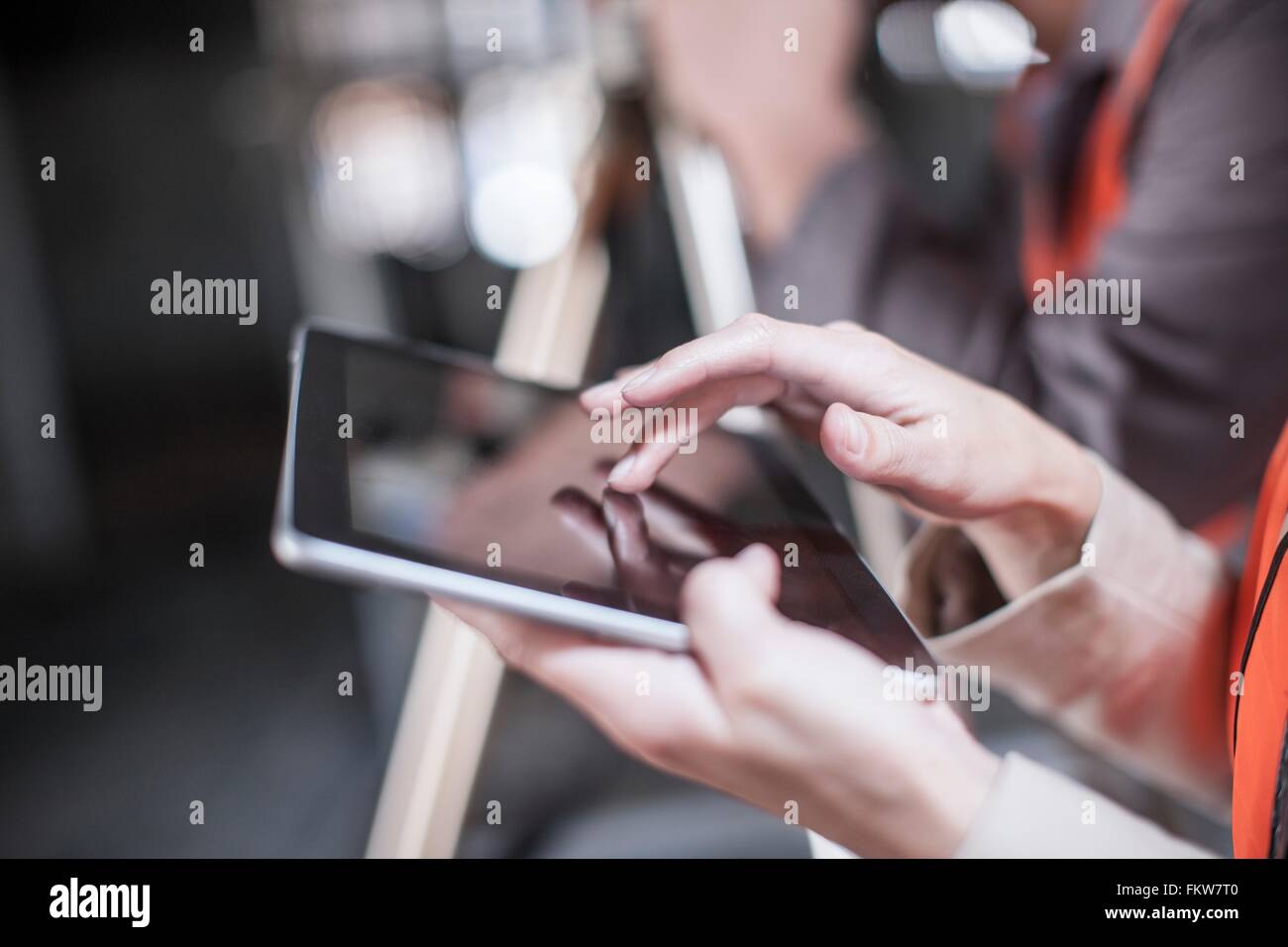 Close up of female surveyor using tablet touchscreen on construction ...