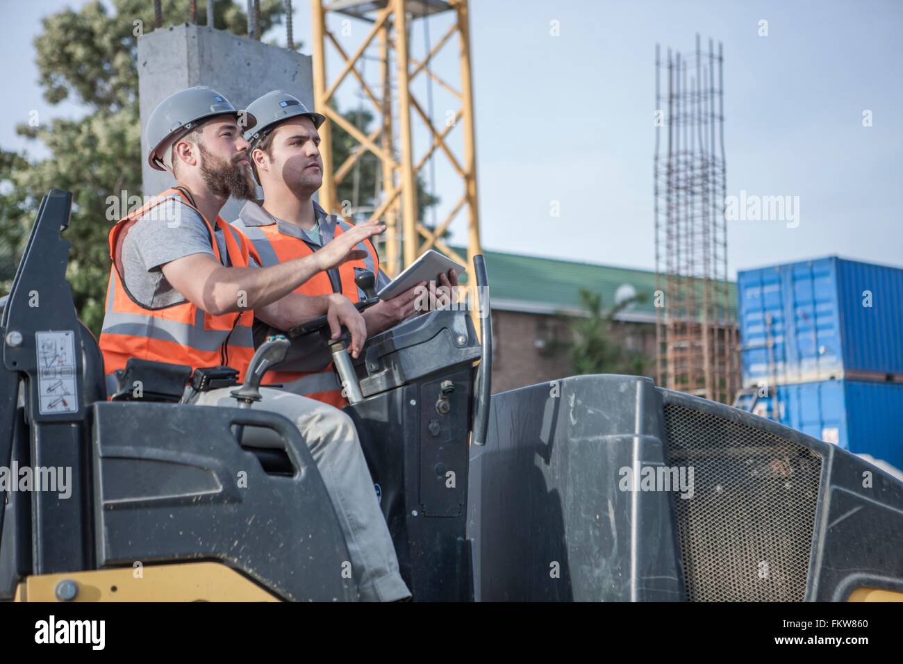 Site manager talking with steamroller driver on construction site Stock ...