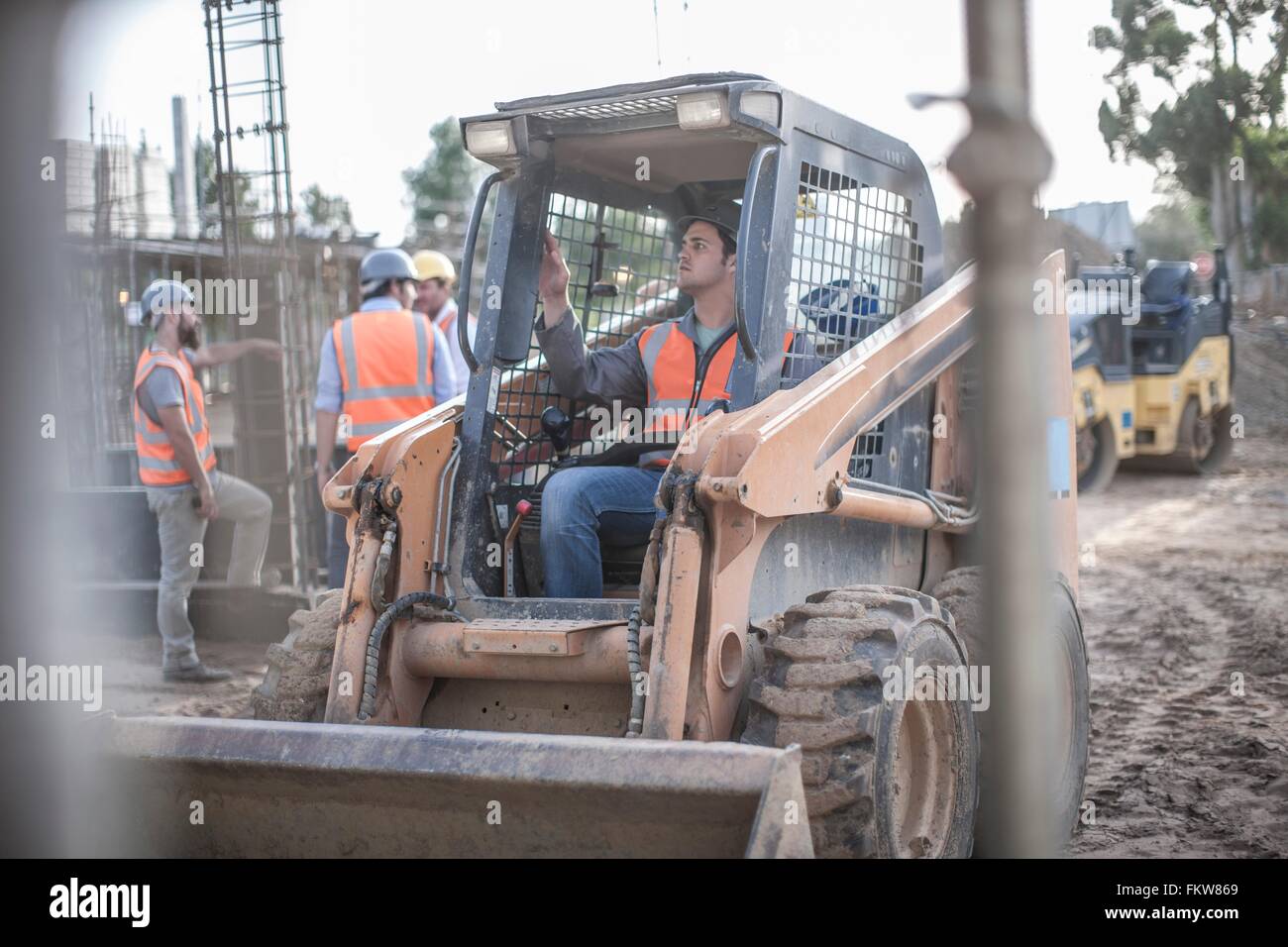 Construction worker driving excavator on construction site Stock Photo ...