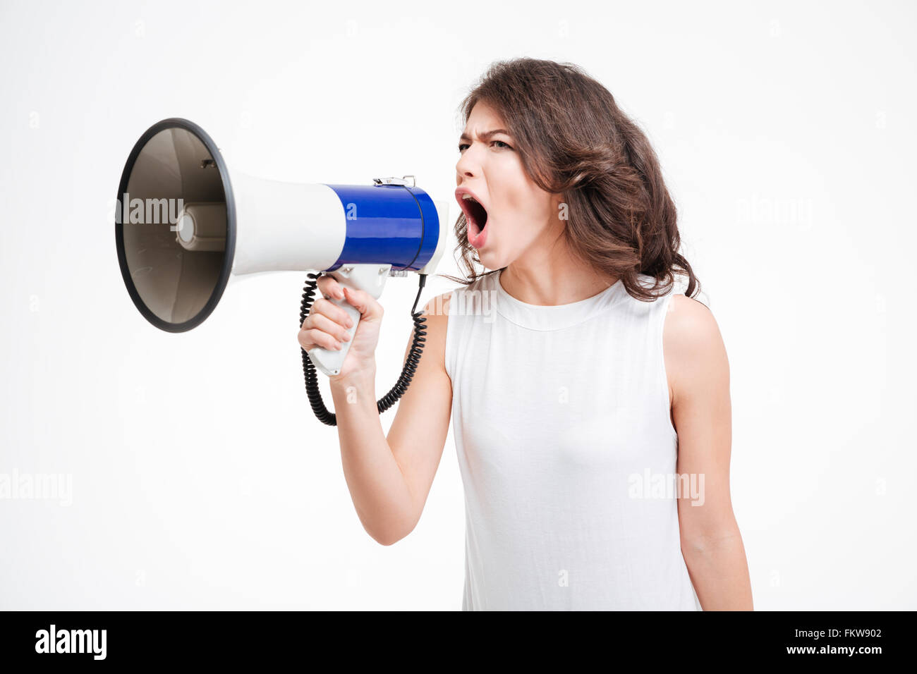 Young woman shouting into loudspeaker isolated on a white background ...