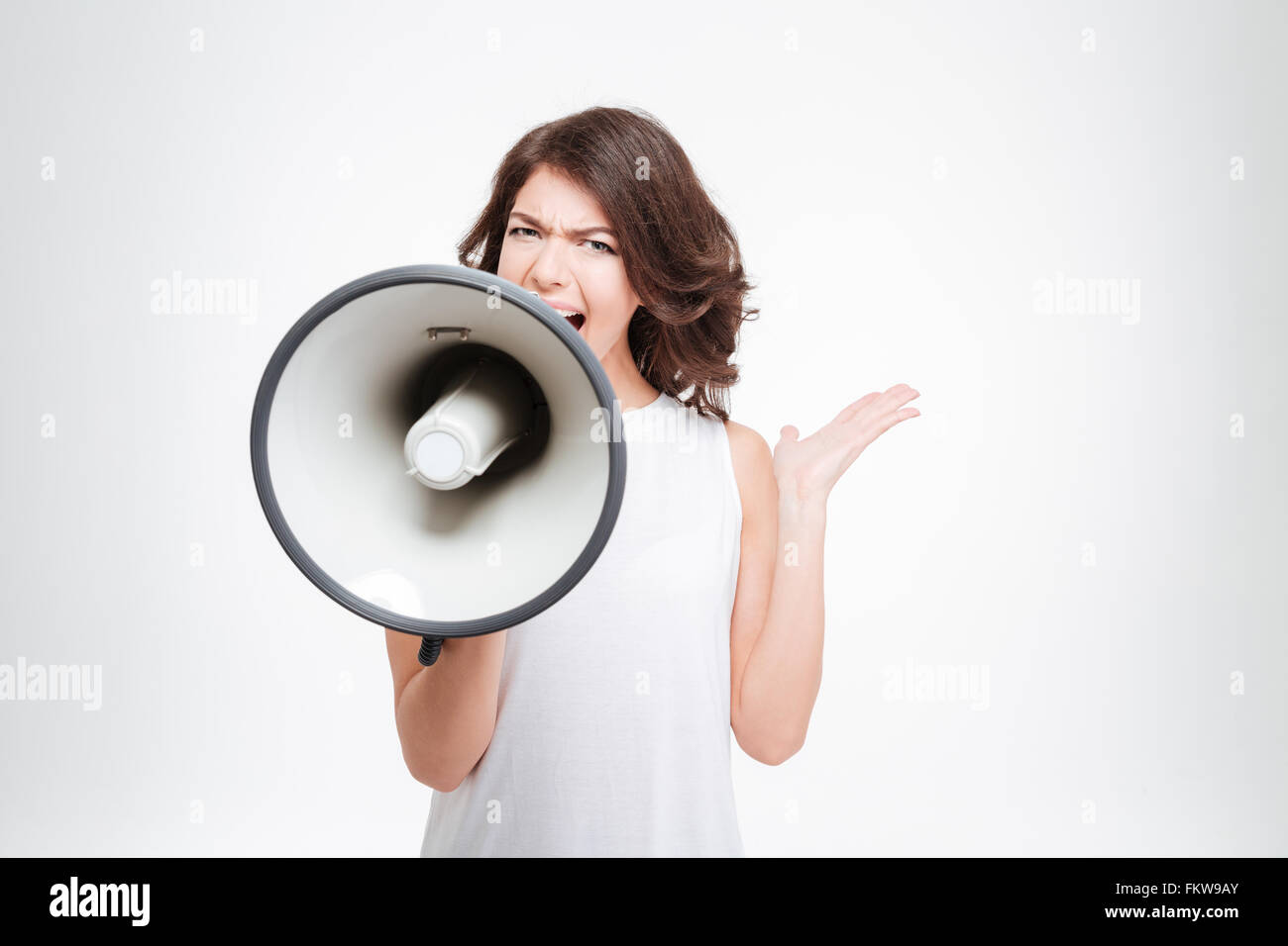 Beautiful woman shouting into megaphone isolated on a white background ...