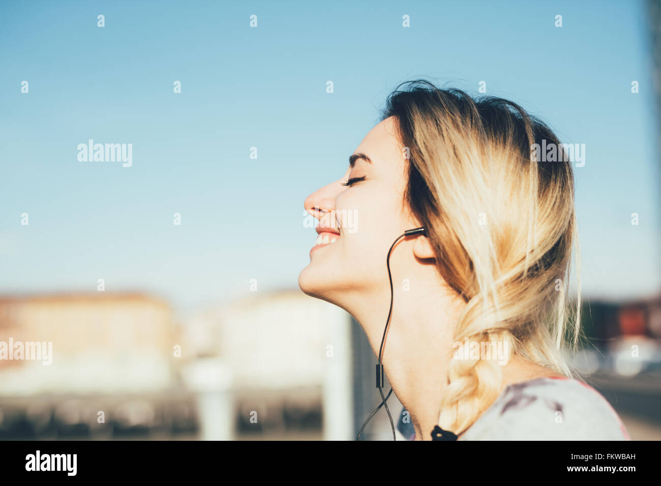 Profile portrait of young beautiful caucasian woman listening music ...