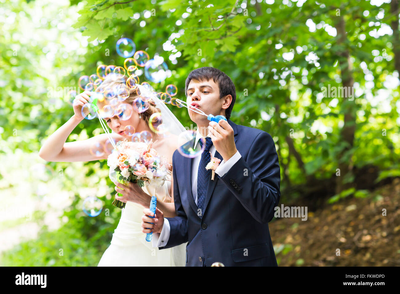 beautiful wedding couple blowing bubbles Stock Photo - Alamy