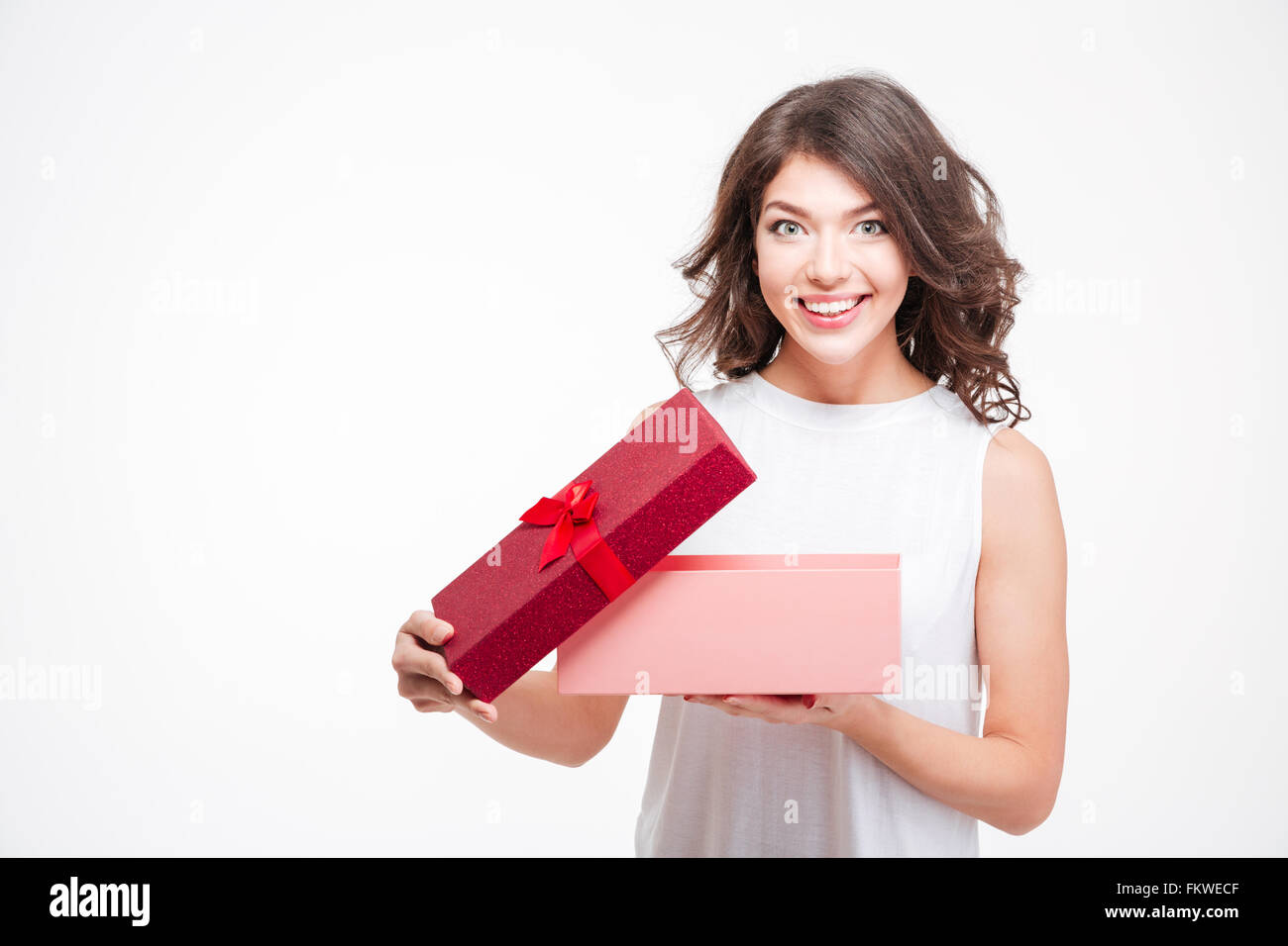 Portrait of a smiling beautiful woman opening gift box isolated on a ...