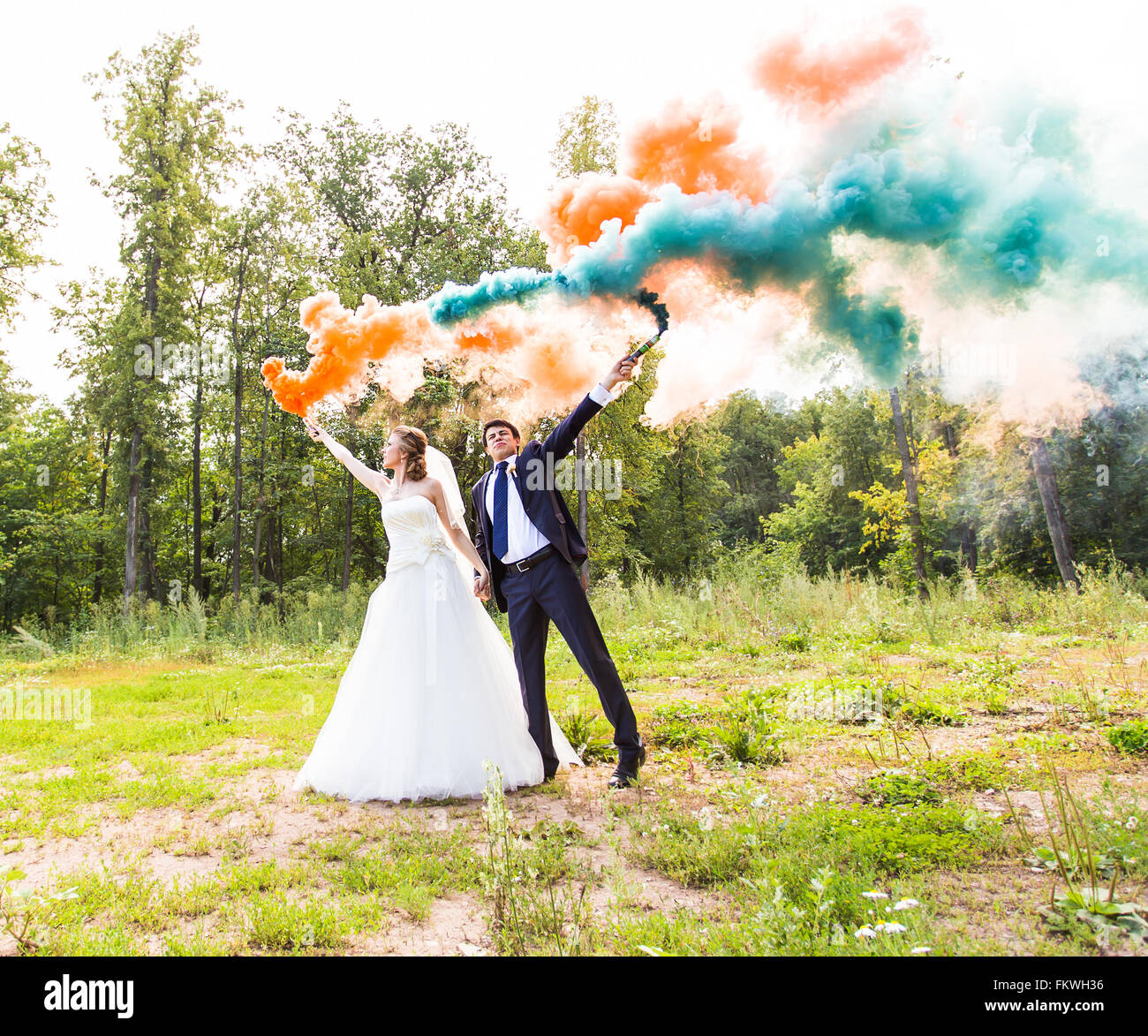 Wedding couple with color smoke in the summer park Stock Photo - Alamy